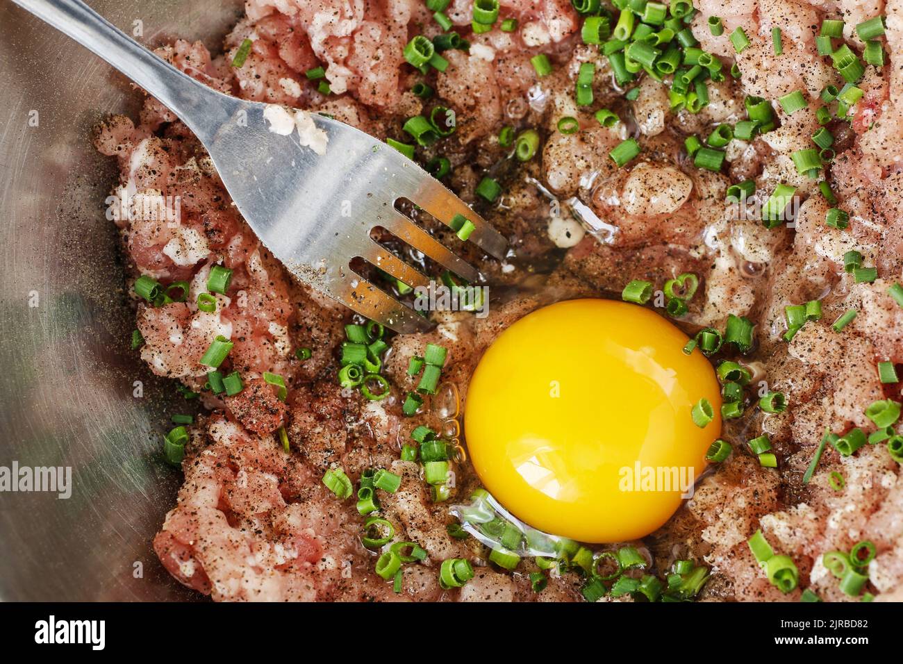 Mixing meat and eggs to prepare the meatballs. Dinner cooking Stock ...