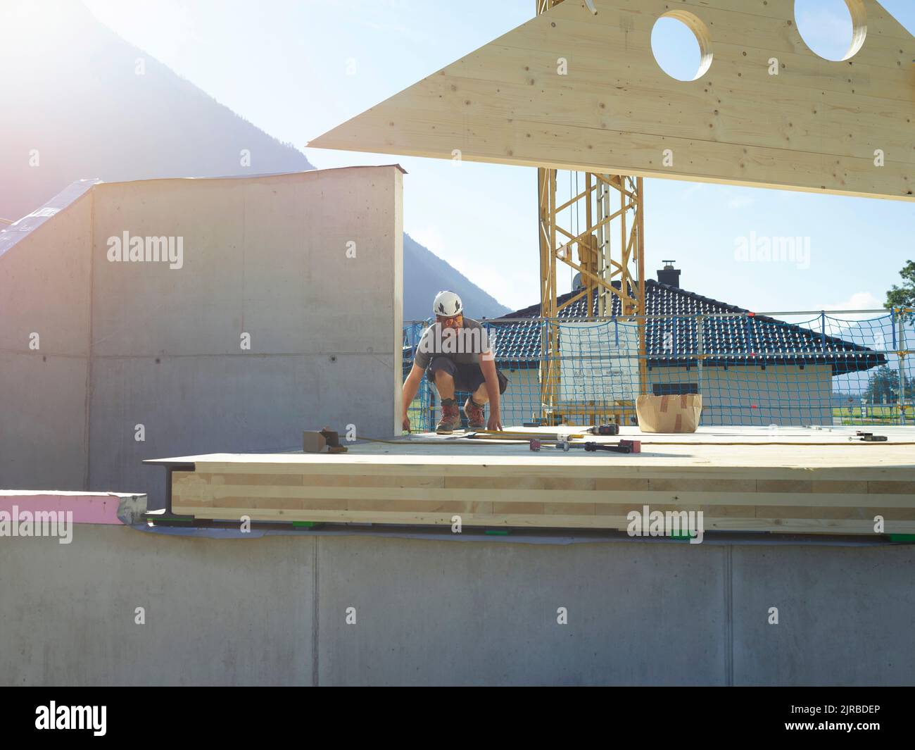 Craftsperson working on rooftop at construction site Stock Photo - Alamy