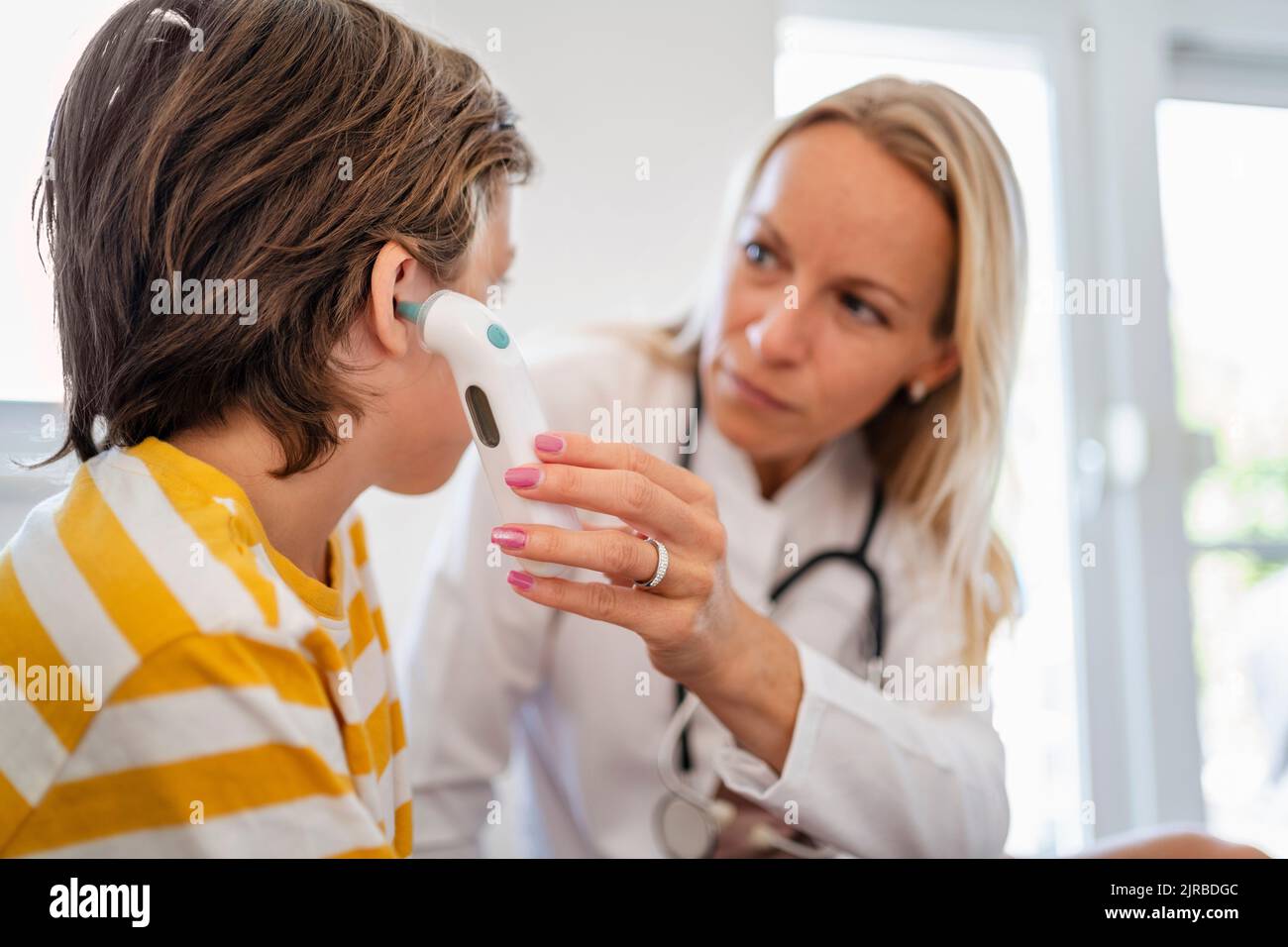 Female doctor examining boy taking his temperature Stock Photo - Alamy