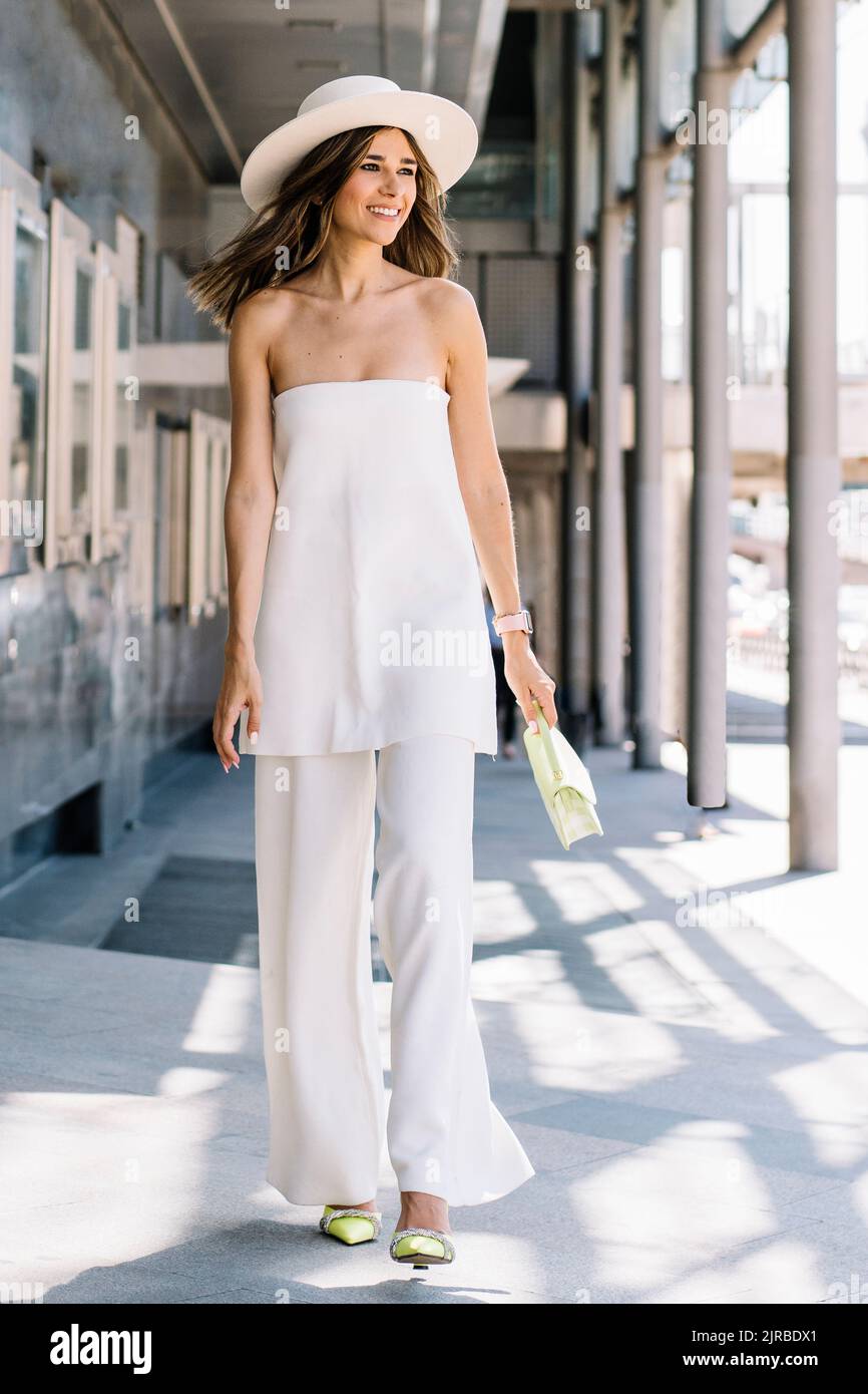Young stylish woman walking on walkway Stock Photo - Alamy