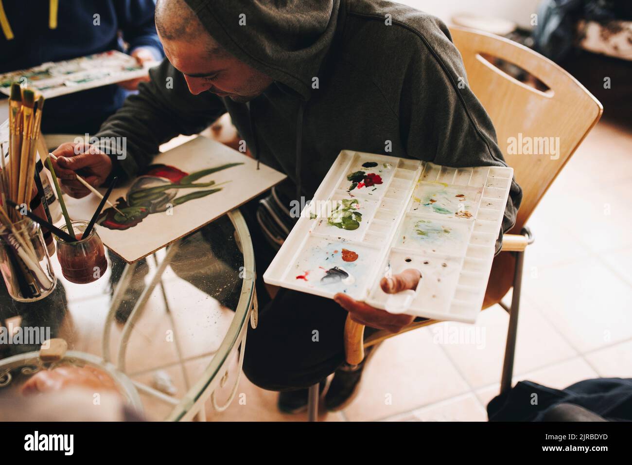 Artist painting with color palette and paintbrush at home Stock Photo ...