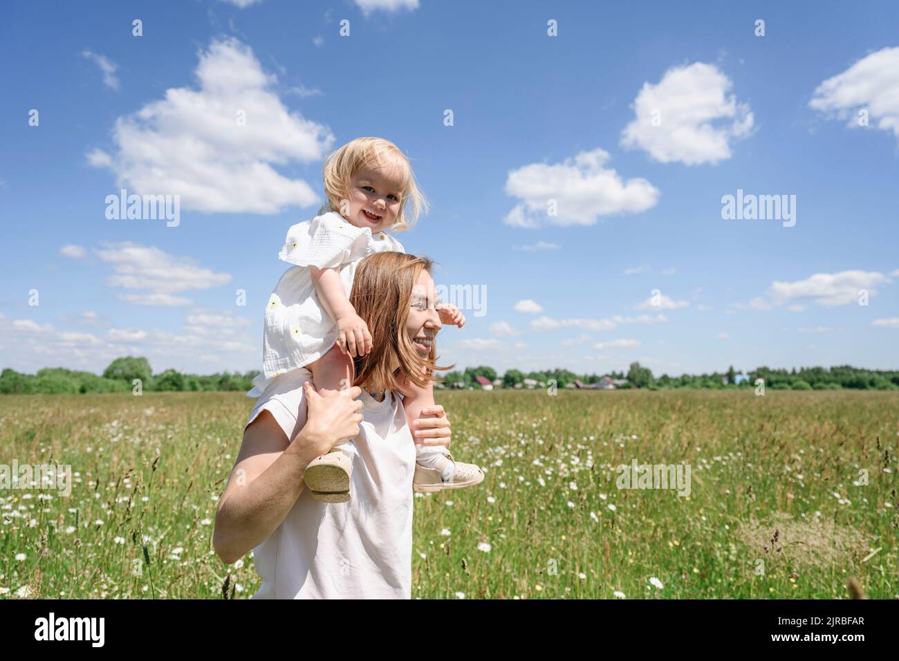 Smiling mother carrying daughter on shoulders at field Stock Photo - Alamy Smiling mother carrying daughter on shoulders at field Stock Photo - Alamy