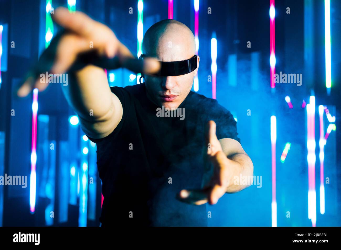 Man with smart glasses gesturing in front of illuminated lights Stock ...