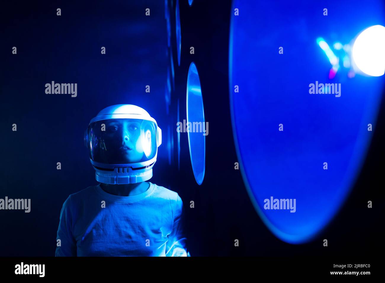 Astronaut wearing space helmet by blue illuminated light Stock Photo ...