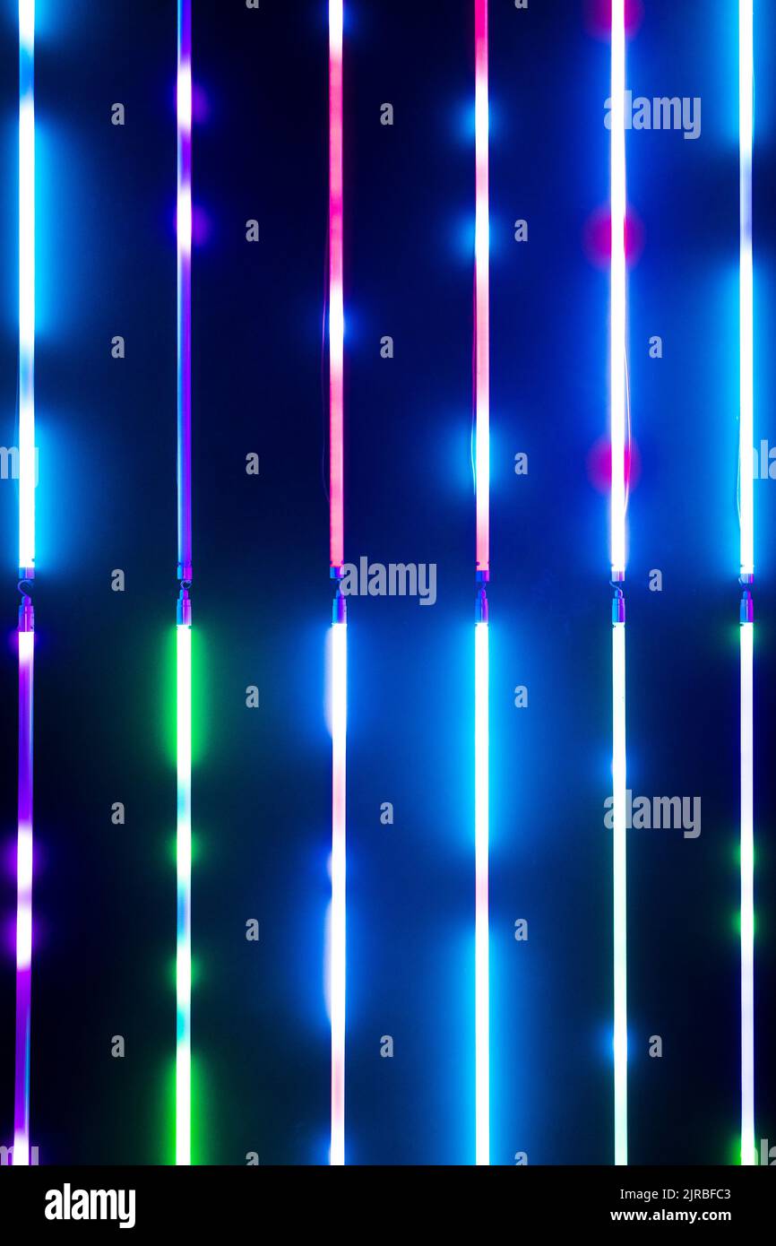 Colourful glowing striped neon lights on black wall Stock Photo - Alamy