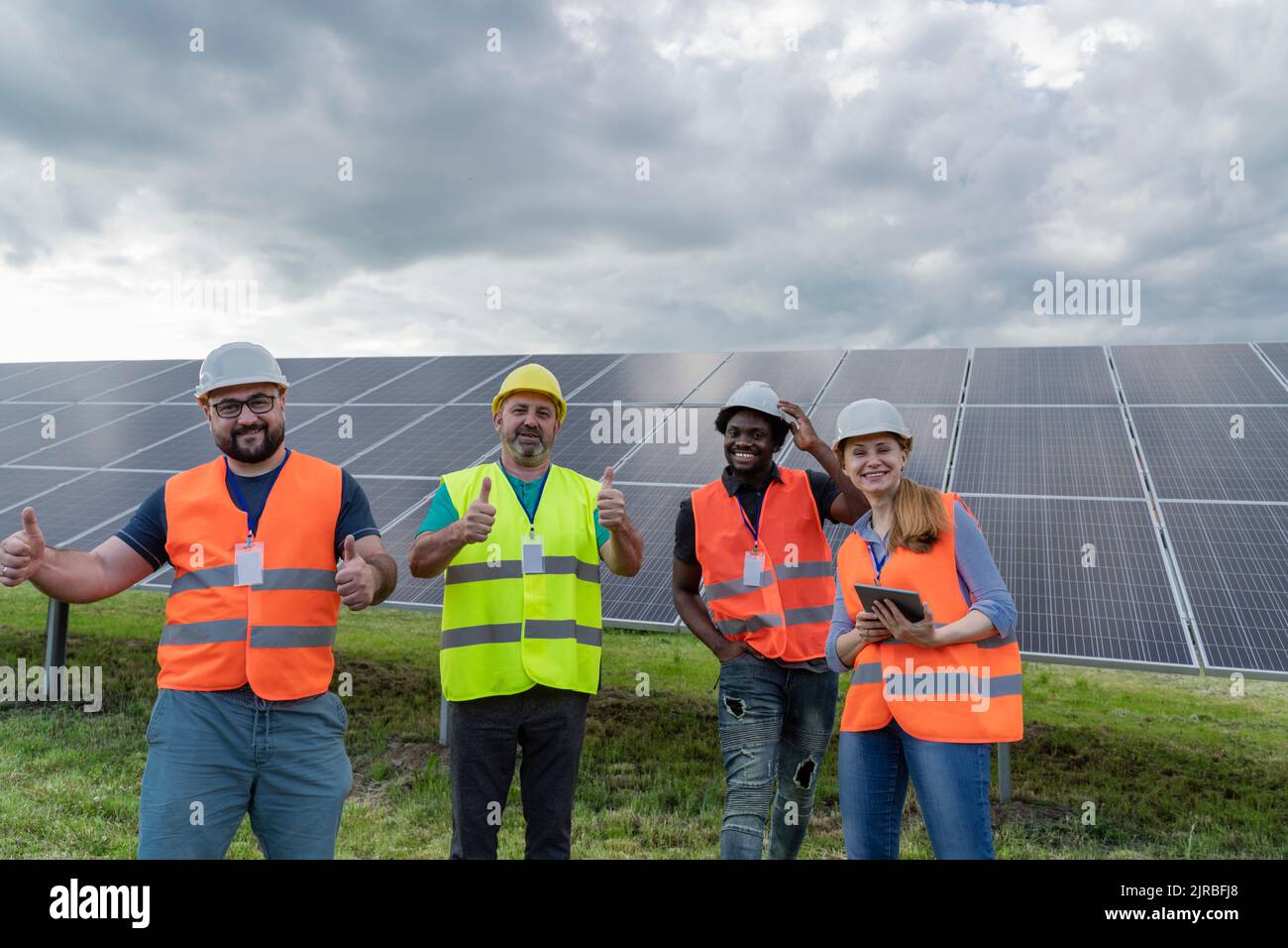 Happy engineers showing thumbs up gesture standing at solar power ...