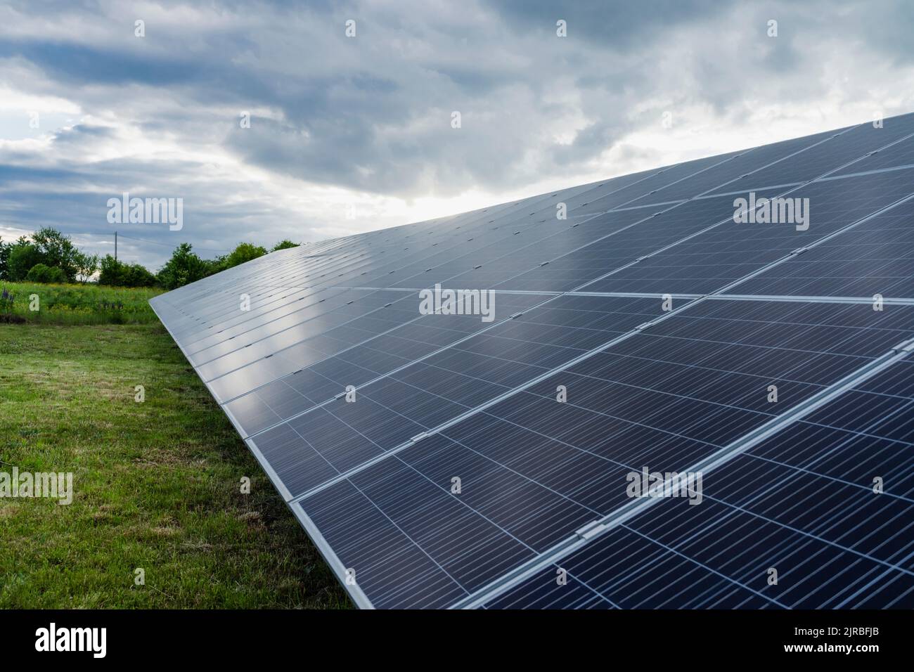 Solar panels under cloudy sky at sunset Stock Photo - Alamy
