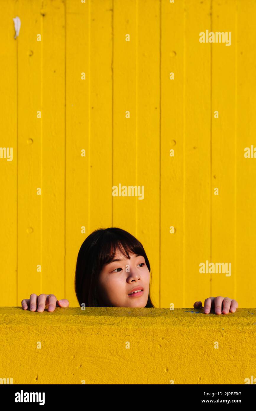 Woman looking over wall hi-res stock photography and images - Alamy