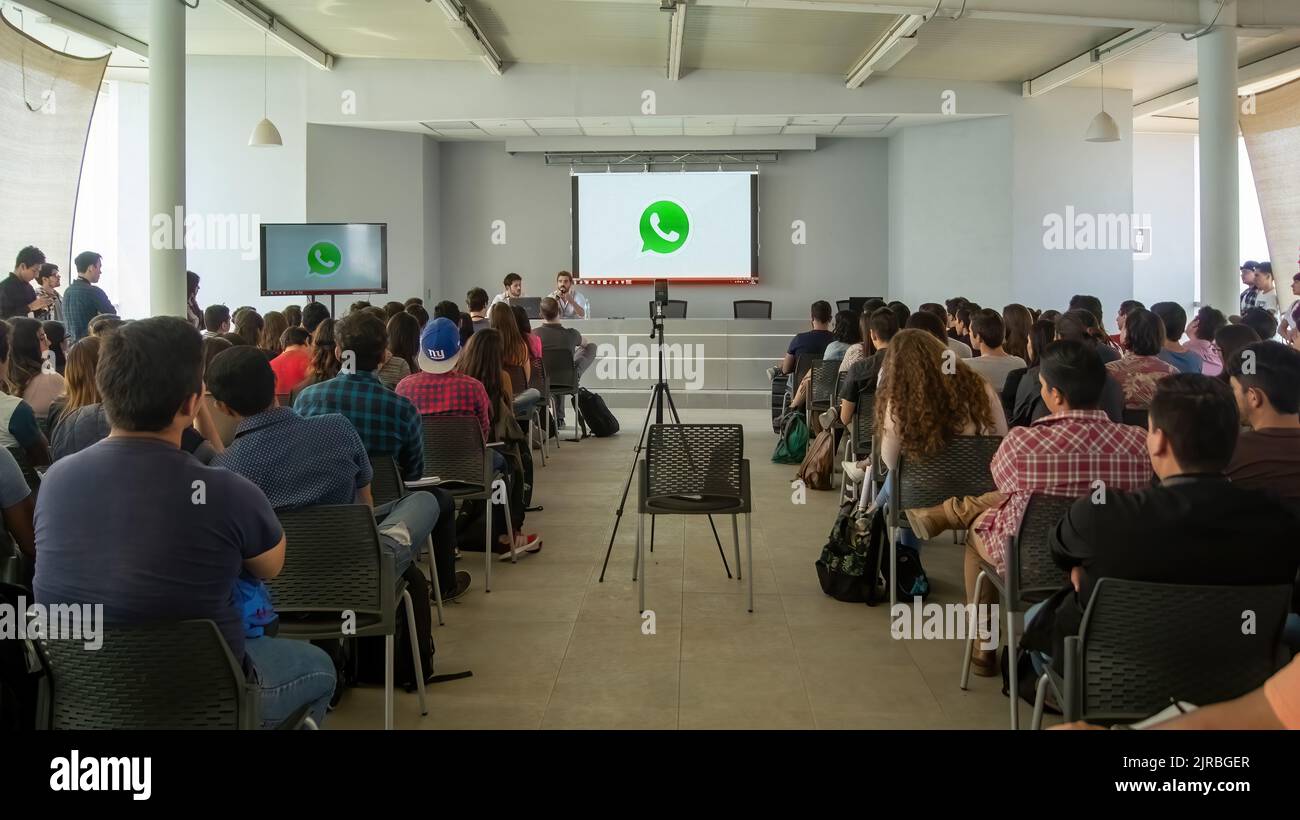 students paying attention to a lecture given by a woman, projecting ...