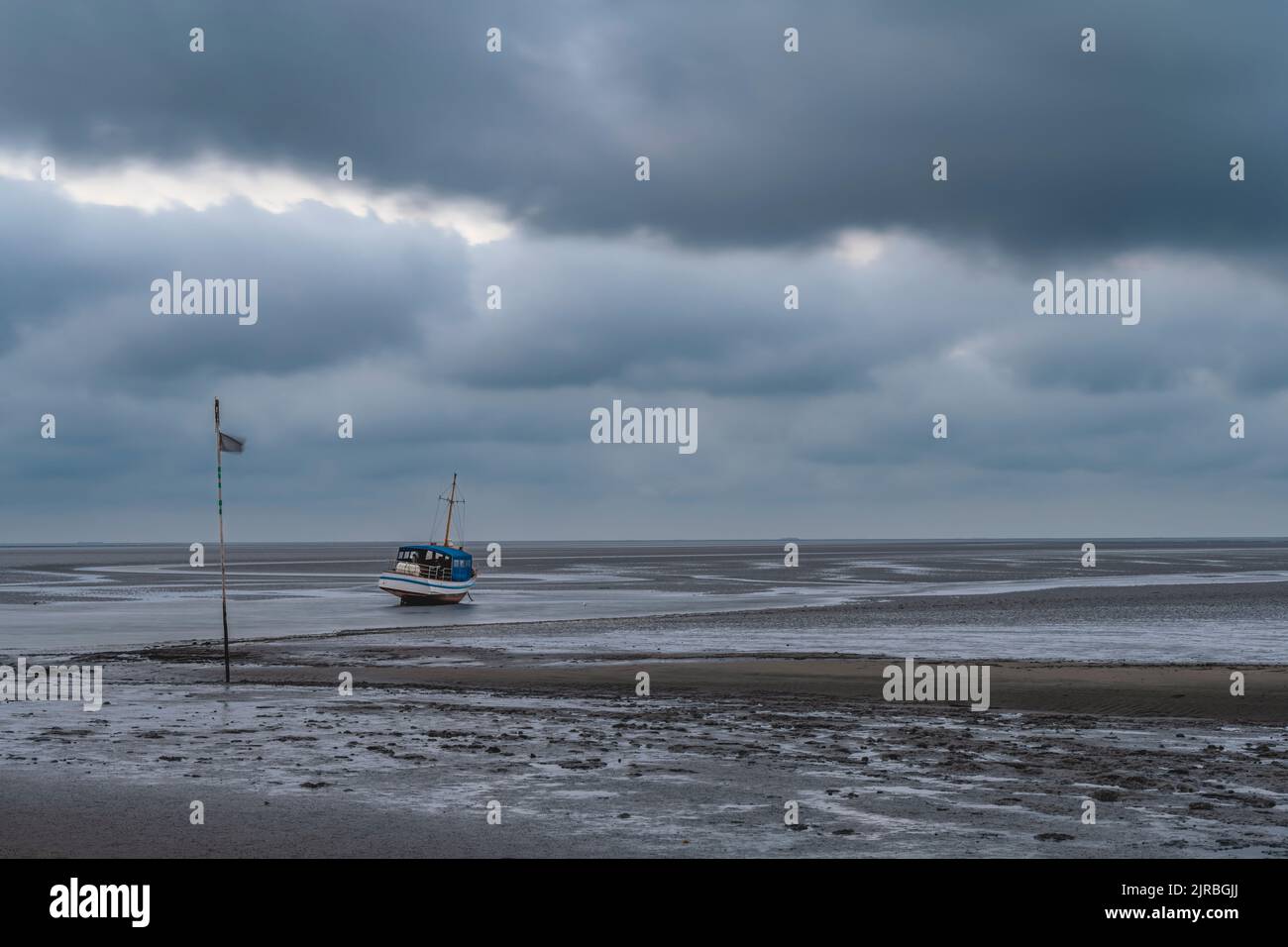 Germany, Schleswig-Holstein, Pellworm, Storm clouds over fishing boat ...