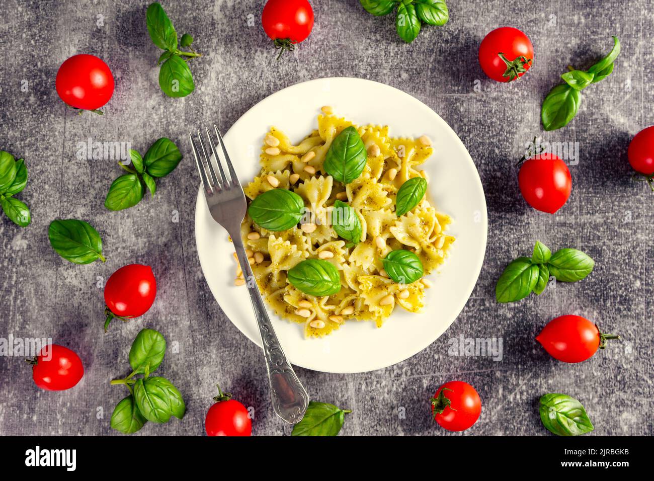 Pasta pesto with fork and fresh pesto sauce on grey concrete background ...