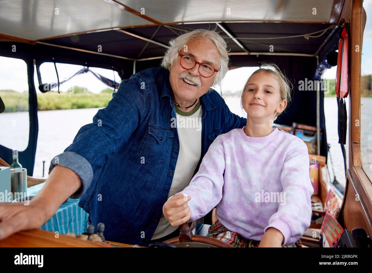 Grandfather teaching sailing to granddaughter in boat Stock Photo - Alamy