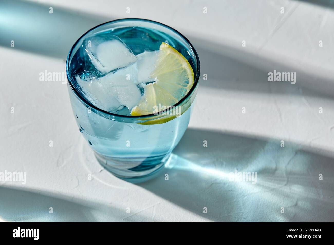 blue glass of water with lemon and ice Stock Photo - Alamy