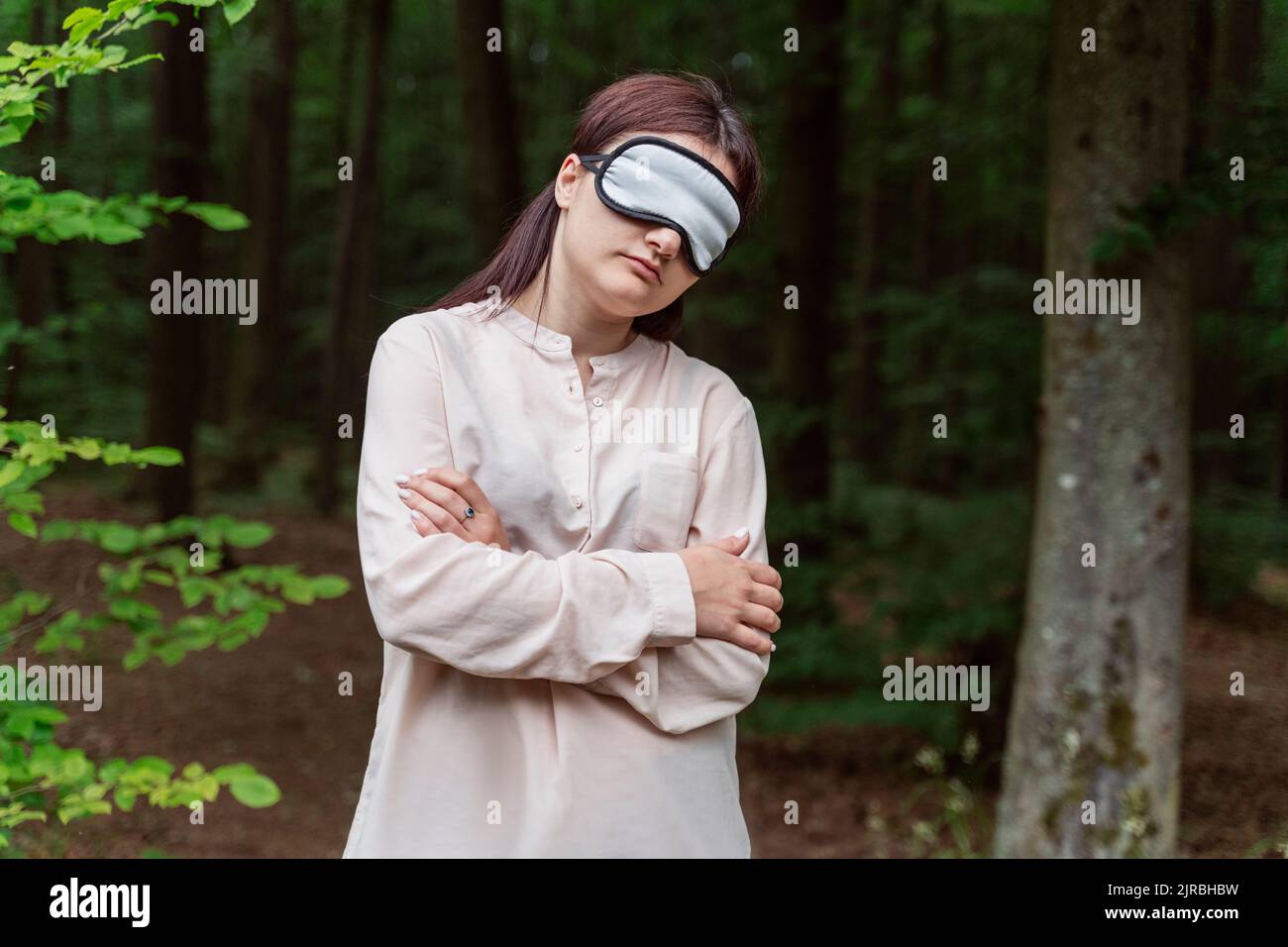 Woman standing with sleeping mask in forest Stock Photo - Alamy