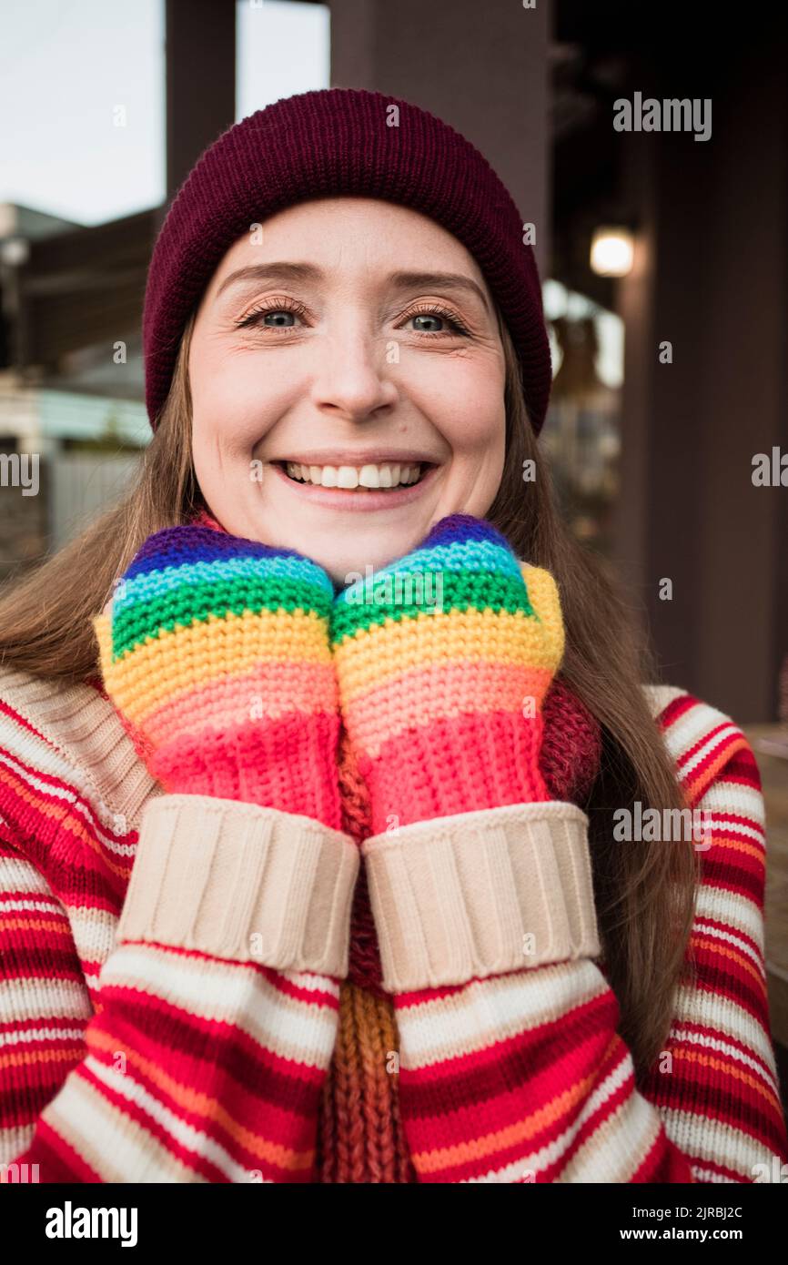 Happy brunette woman with hands on chin Stock Photo - Alamy