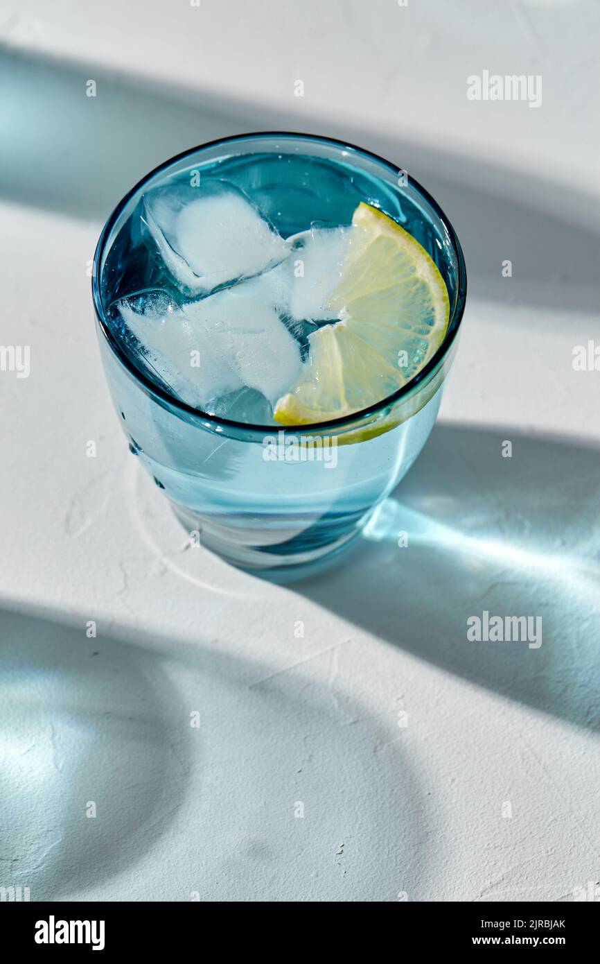 blue glass of water with lemon and ice Stock Photo - Alamy