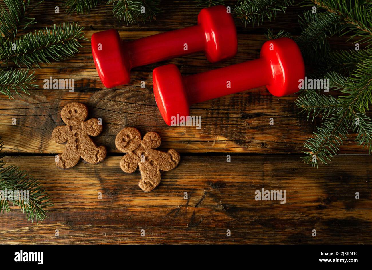 Gingerbread man cookies, dumbbells and Christmas tree branches. Healthy ...