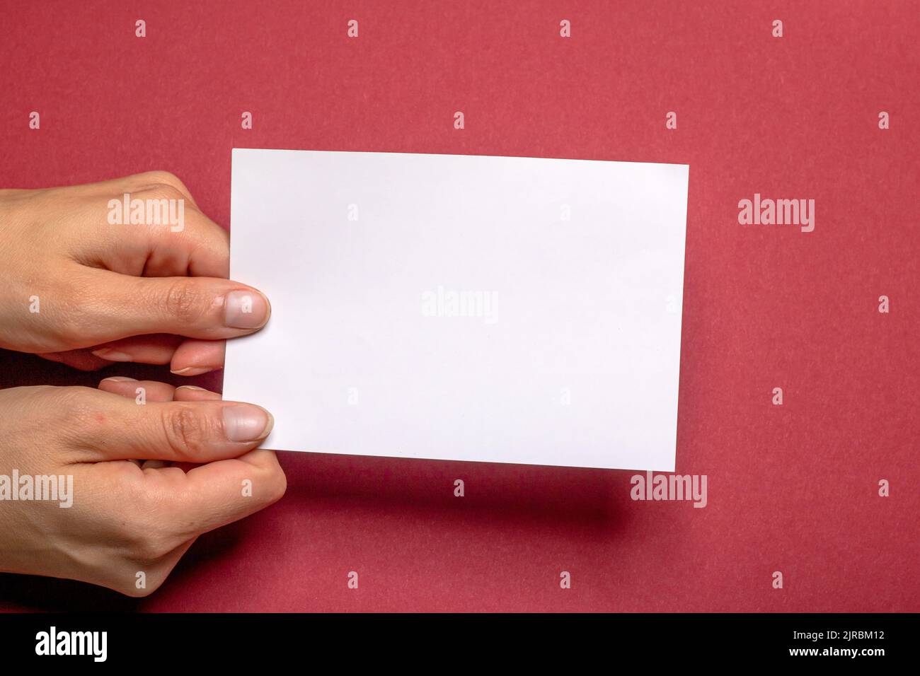 two female hands holding a blank piece of paper with copy space in ...