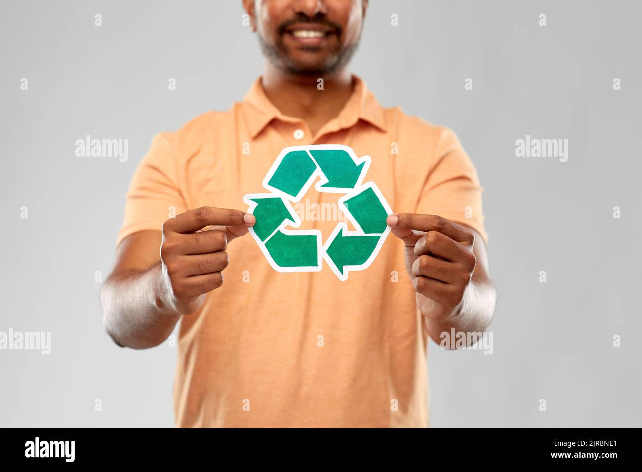 smiling indian man holding green recycling sign Stock Photo - Alamy