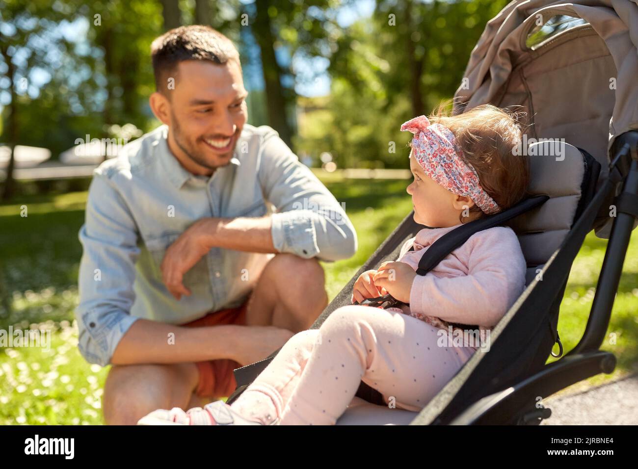happy father with child in stroller at summer park Stock Photo - Alamy
