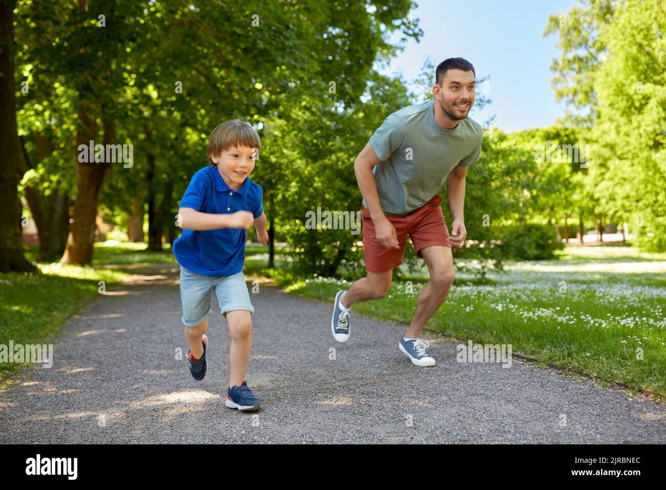 happy father and son compete in running at park Stock Photo - Alamy