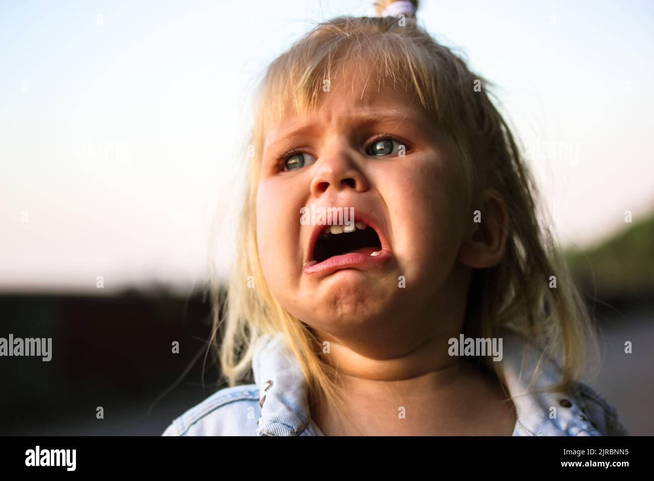 An unhappy sad child crying profusely close-up portrait. An ugly ...