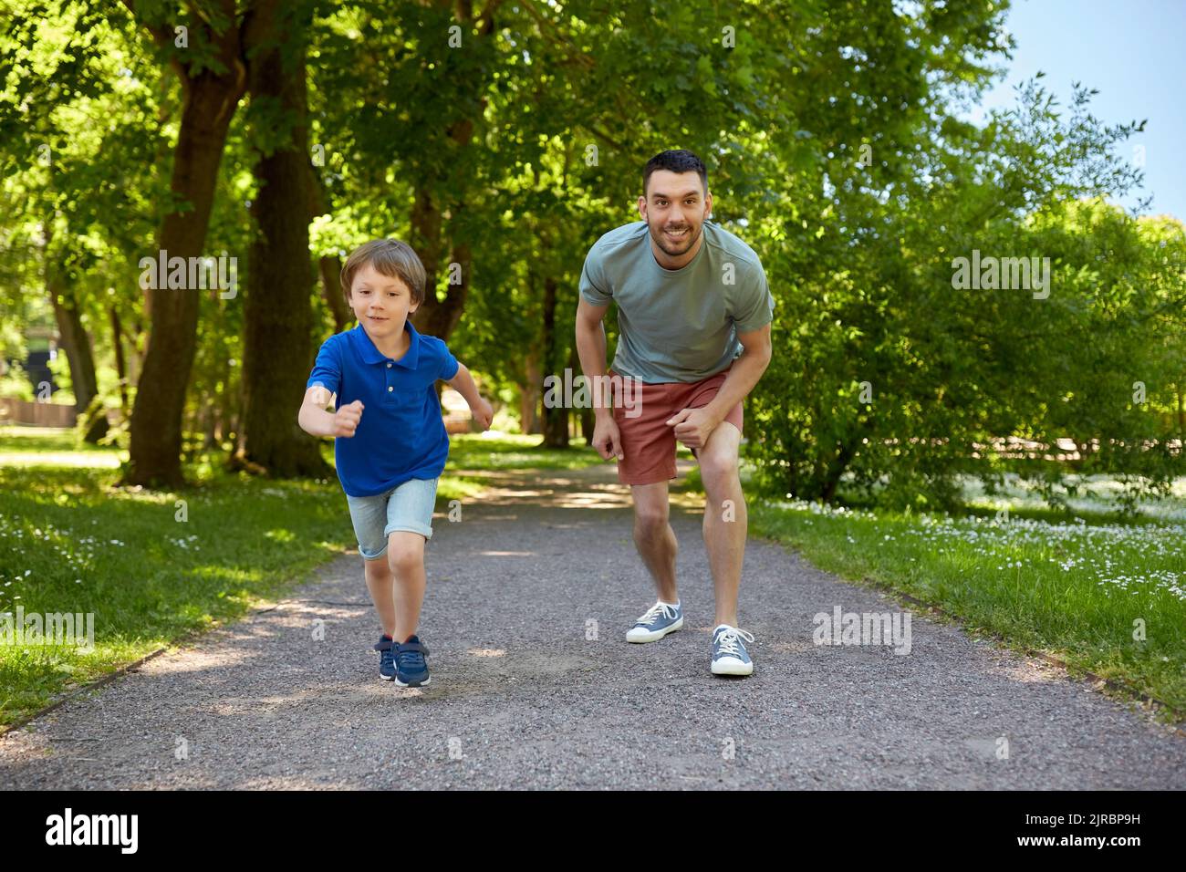 happy father and son compete in running at park Stock Photo - Alamy