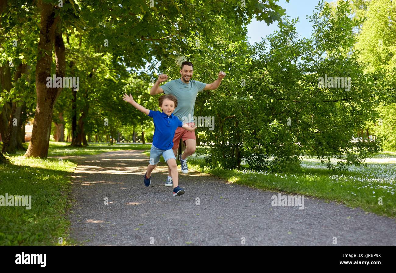 happy father and son compete in running at park Stock Photo - Alamy