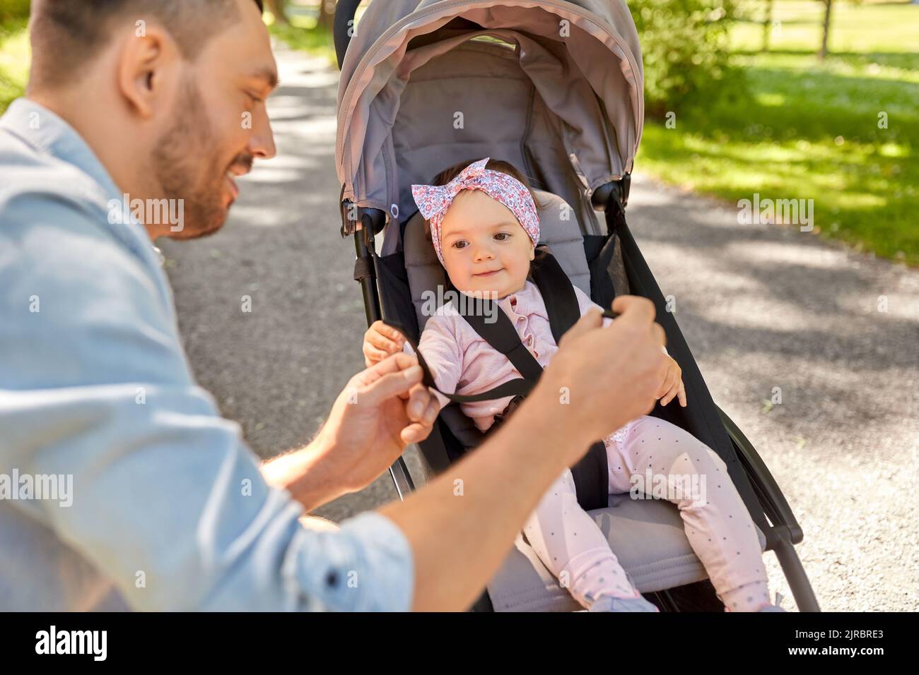 happy father with child in stroller at summer park Stock Photo - Alamy