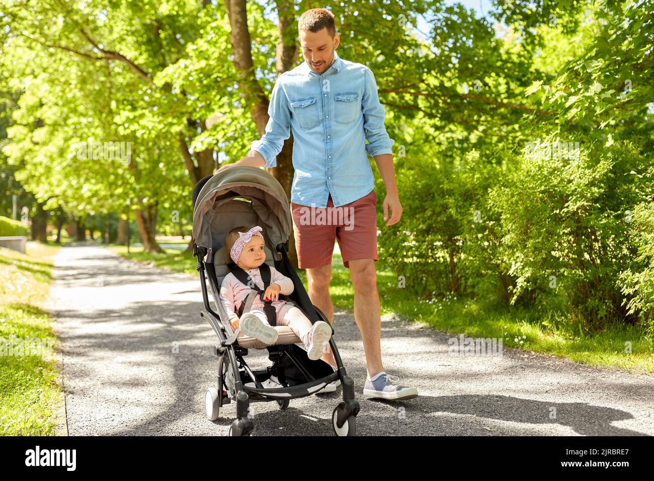 happy father with child in stroller at summer park Stock Photo - Alamy