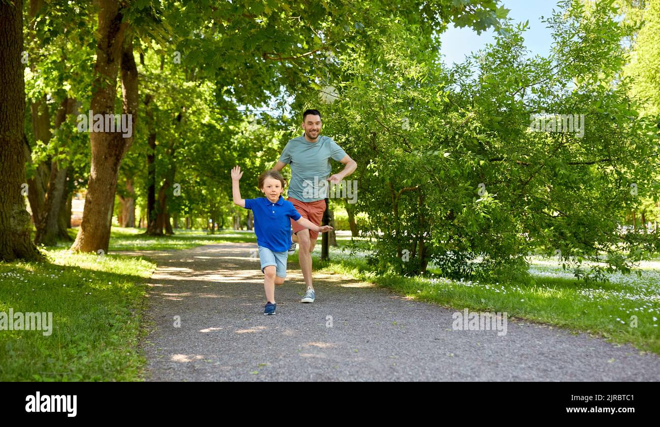happy father and son compete in running at park Stock Photo - Alamy