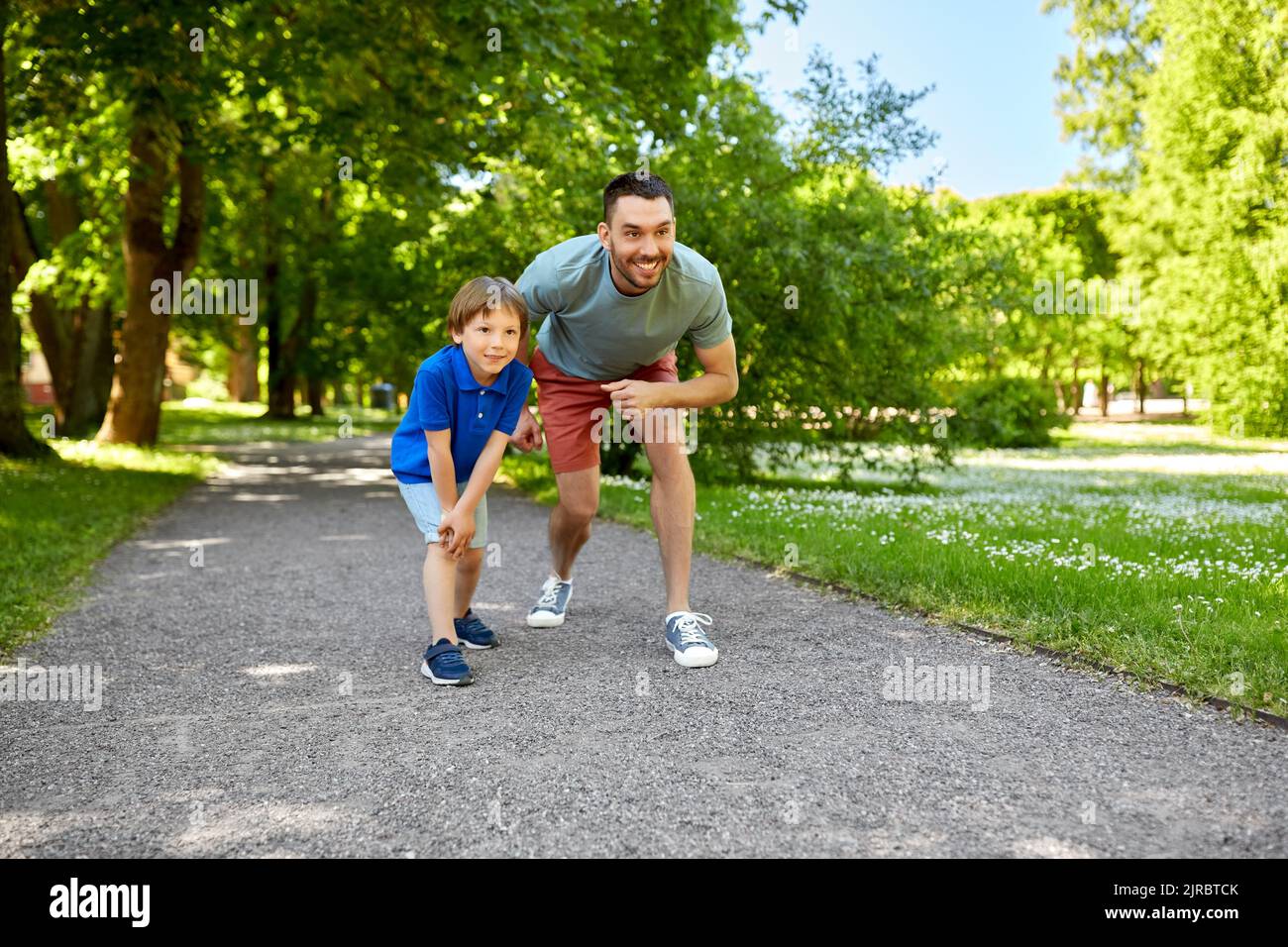 happy father and son compete in running at park Stock Photo - Alamy