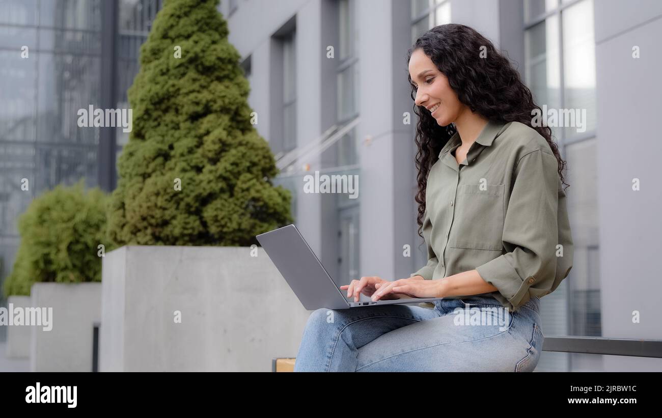 Woman user journalist writer worker freelancer sitting on bunch near ...