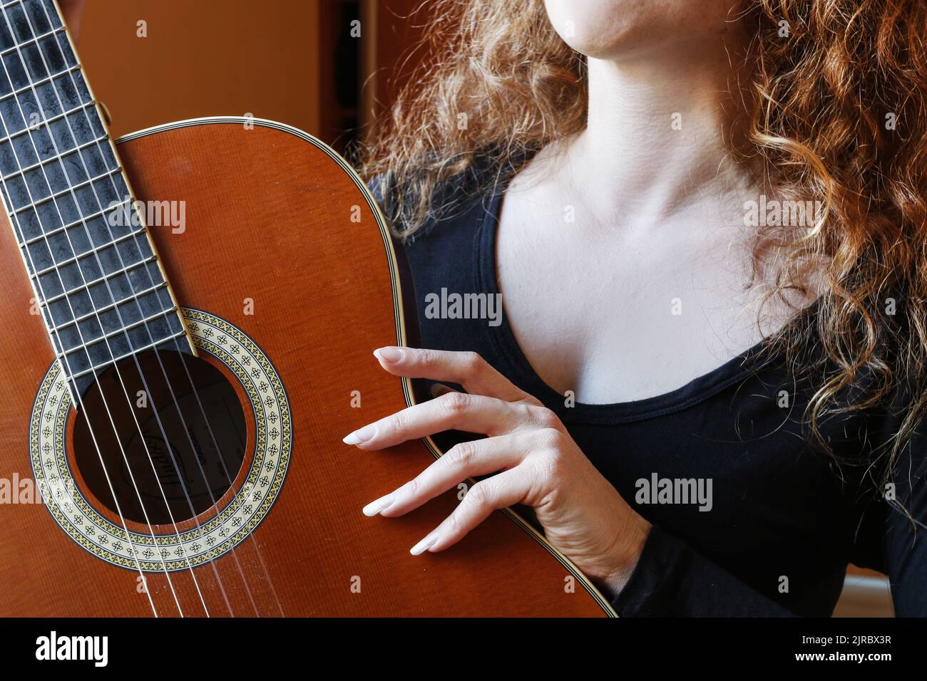 Red haired woman with a traditional acoustic guitar. Music player Stock ...