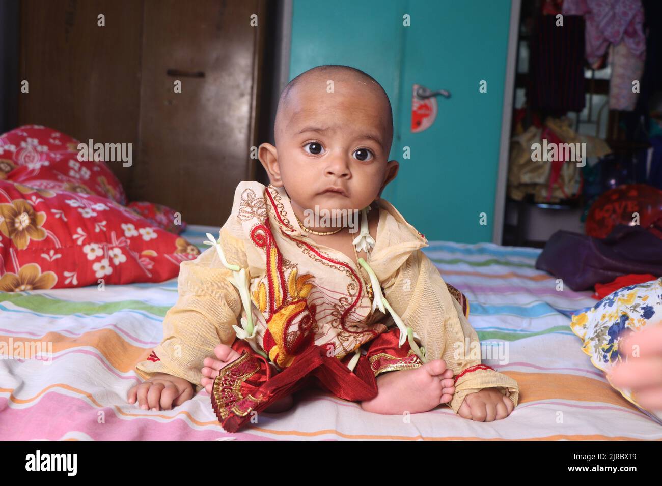Cute little indian infant sitting on bed Stock Photo - Alamy