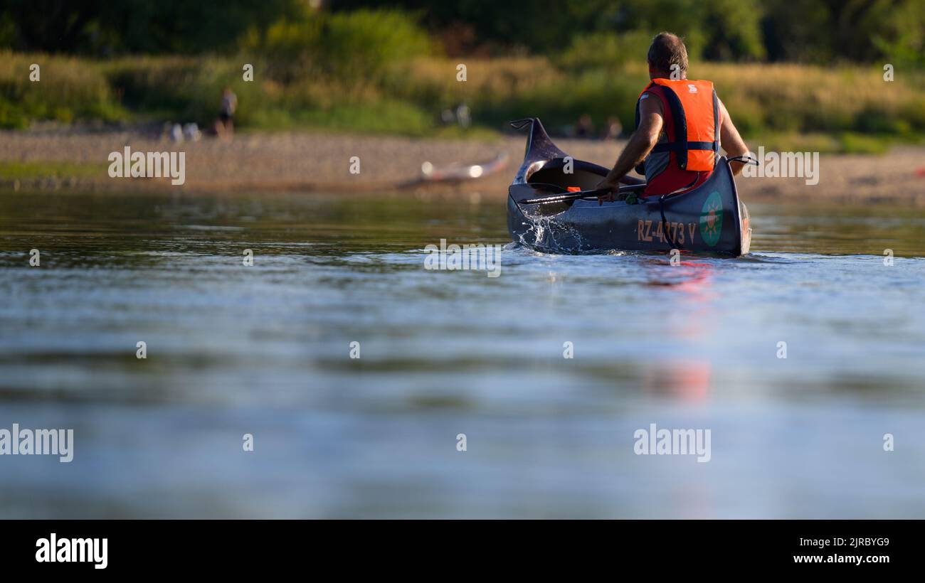 Darchau, Germany. 23rd Aug, 2022. Sigurd uses a canoe to cross the Elbe ...