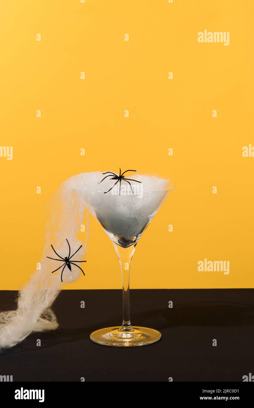 Creative layout made of martini glass, spider's web and spiders on ...