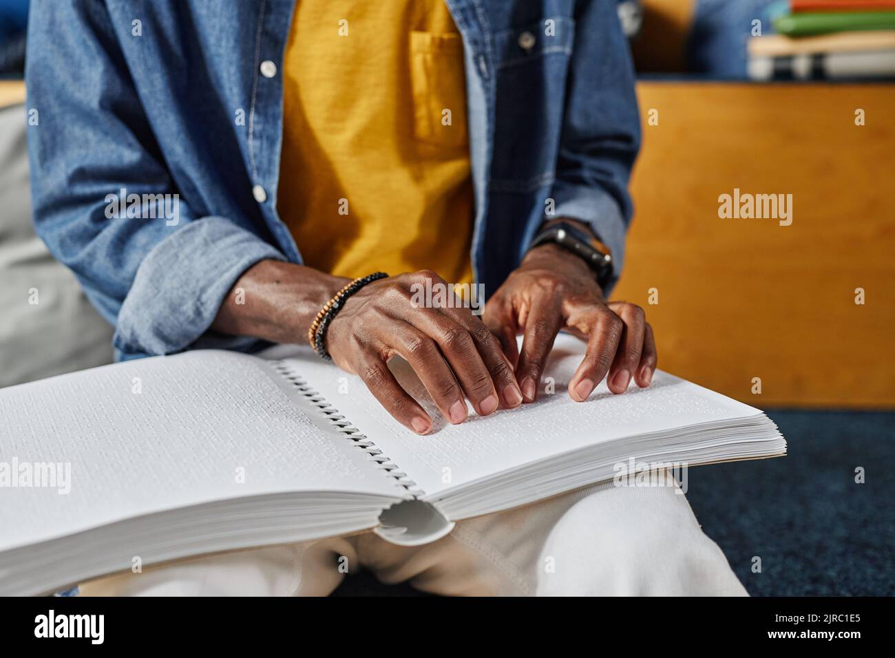 Close up of blind African American man reading book in braille in ...