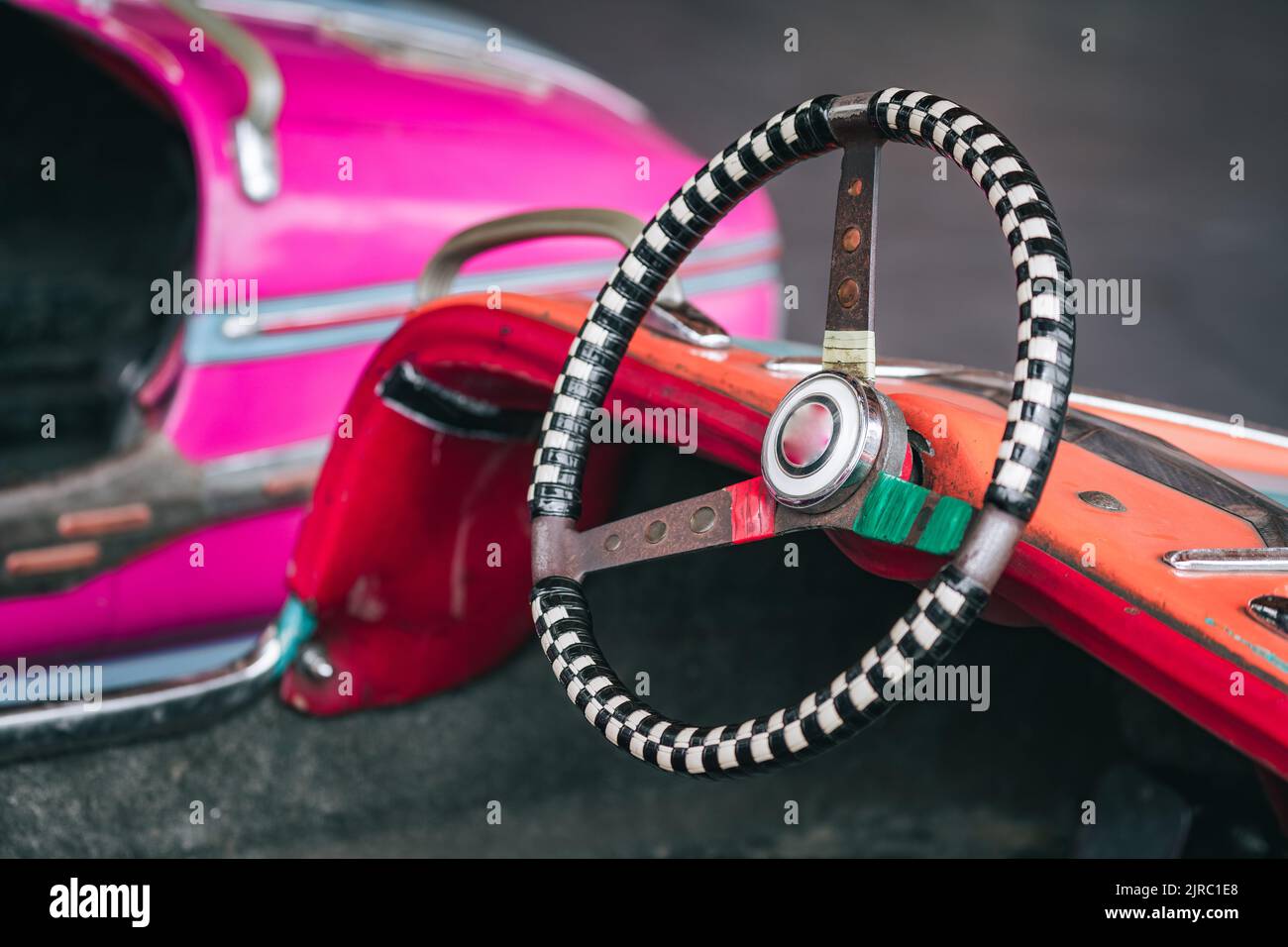 A closeup of a steering wheel on a colorful vintage bumper car in an ...