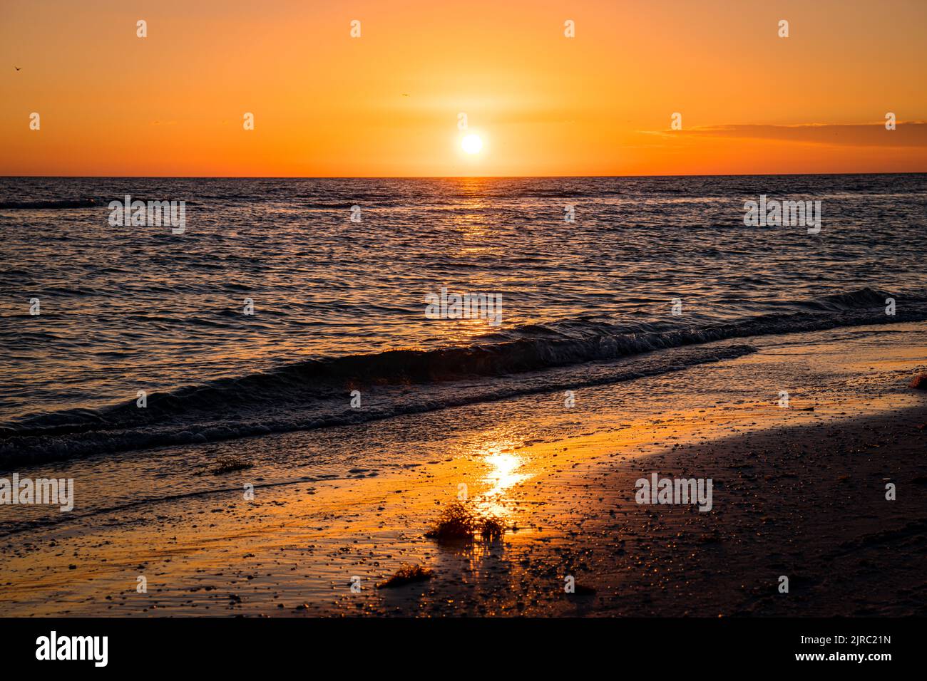 A beautiful view of the sea with a sandy beach at sunset Stock Photo ...