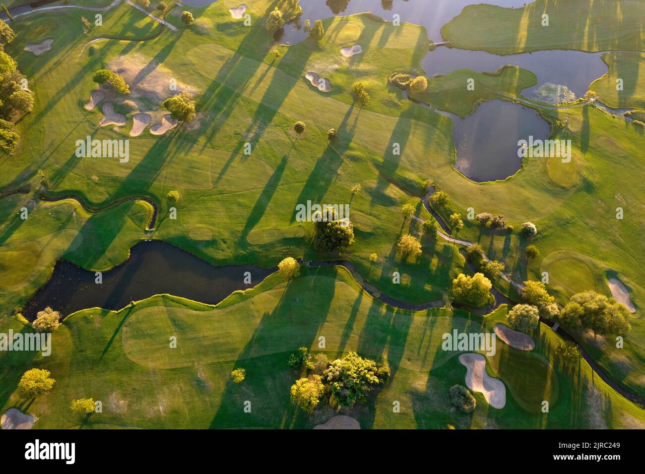 Aerial photographic documentation of a golf course taken at sunset ...