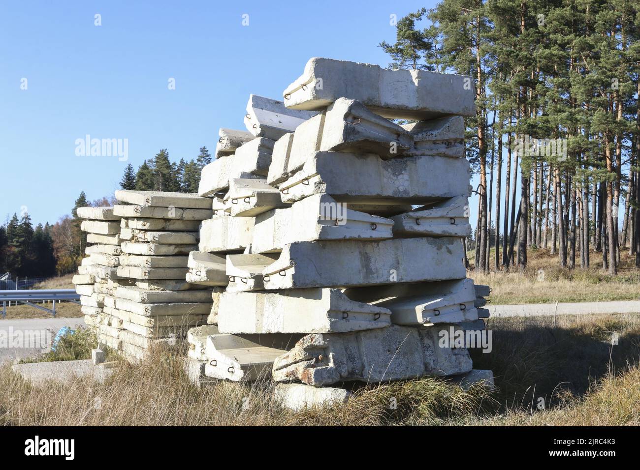 A pile of concrete building elements and a high trees in the background ...