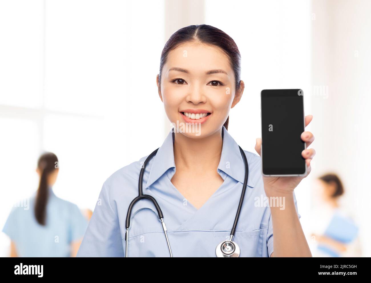 asian female nurse with smartphone at hospital Stock Photo - Alamy