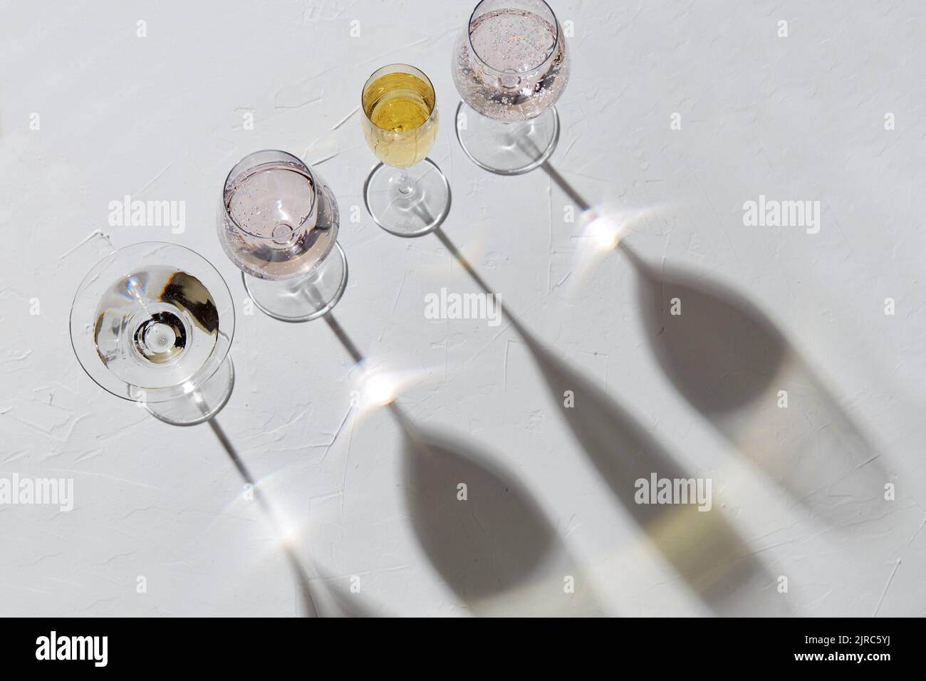 wine glasses dropping shadows on white surface Stock Photo - Alamy