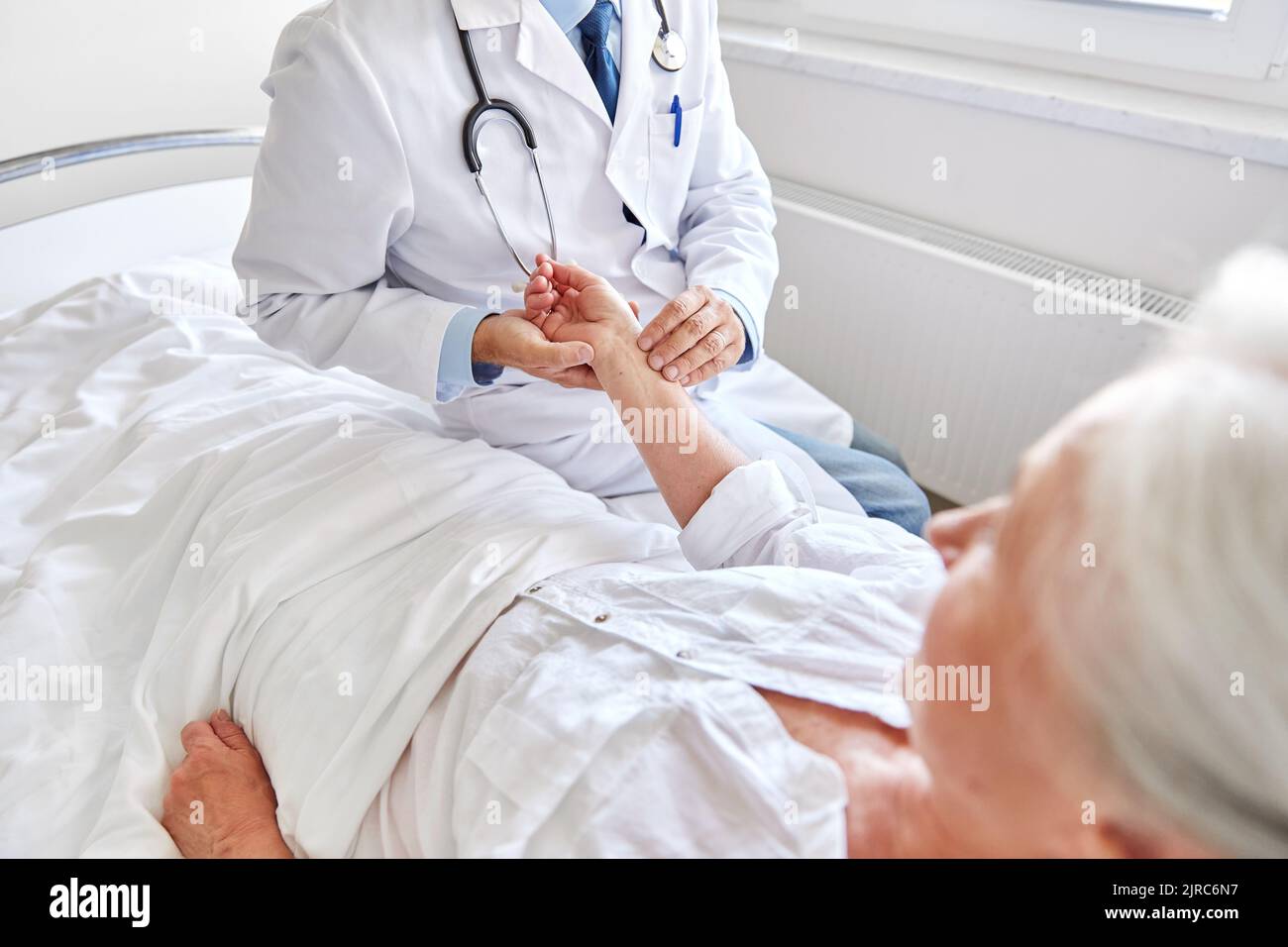 doctor checking senior woman pulse at hospital Stock Photo - Alamy