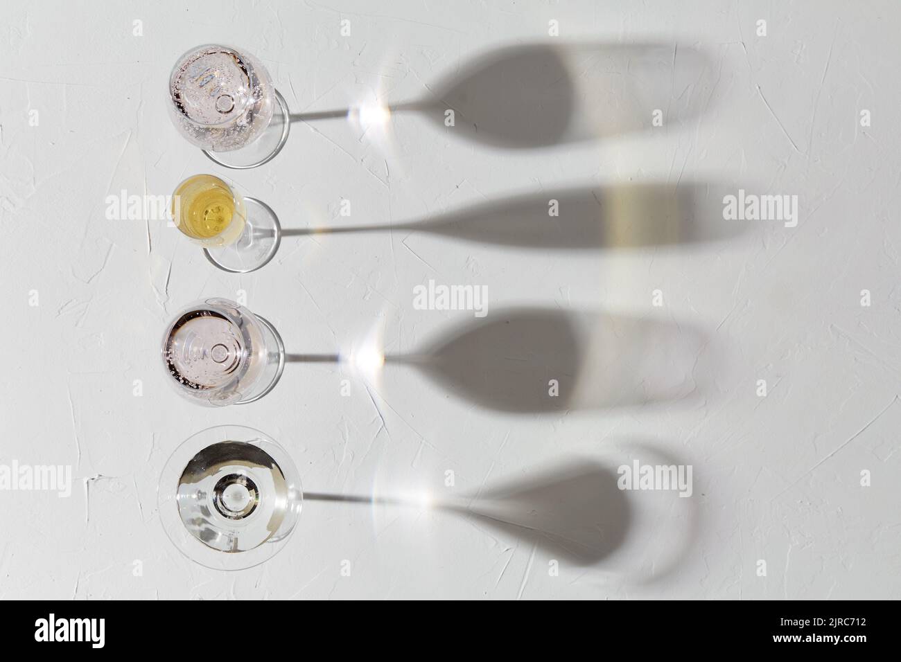 wine glasses dropping shadows on white surface Stock Photo - Alamy