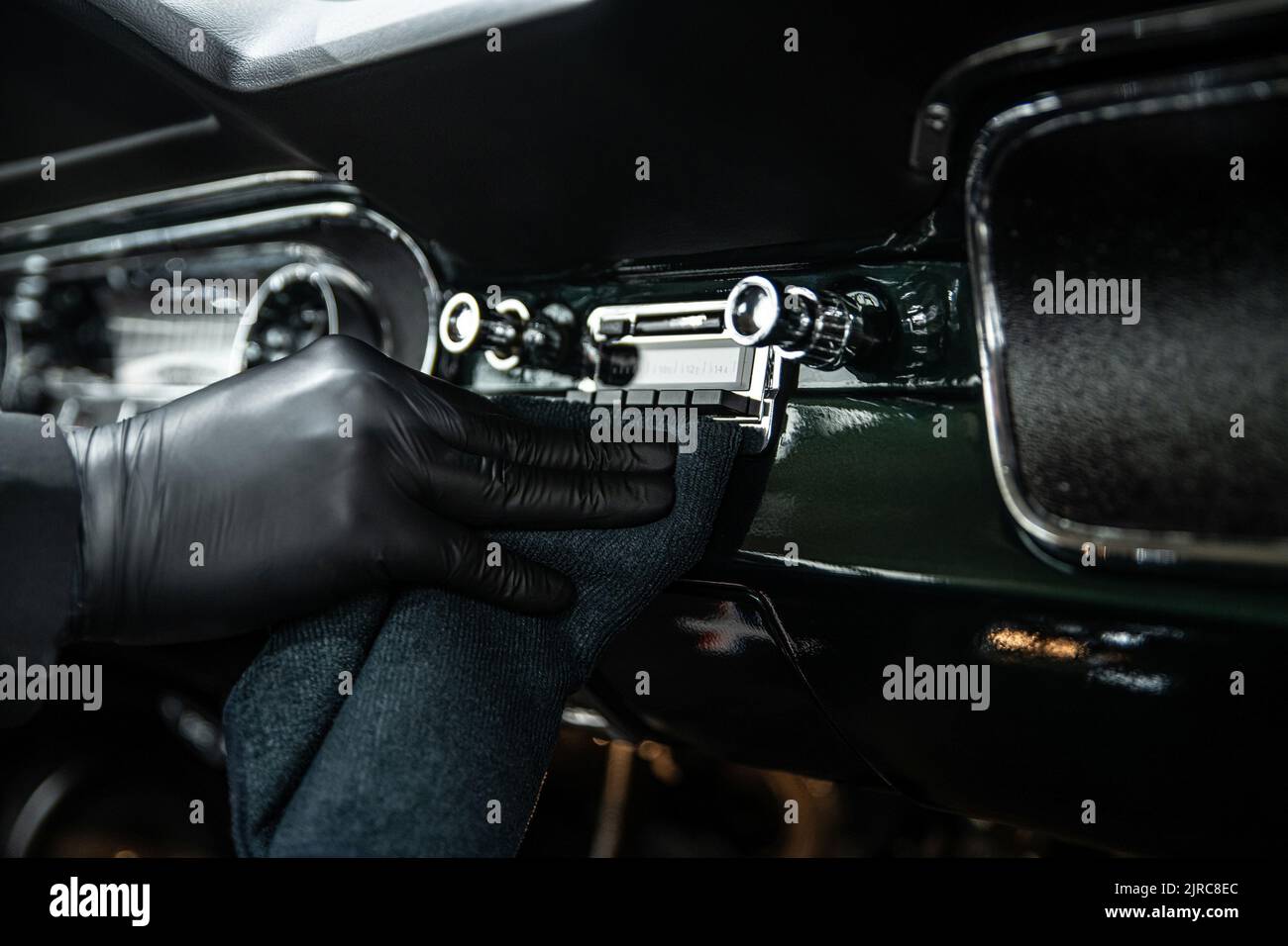 Car detailing studio worker cleans the interior of a classic car Stock ...