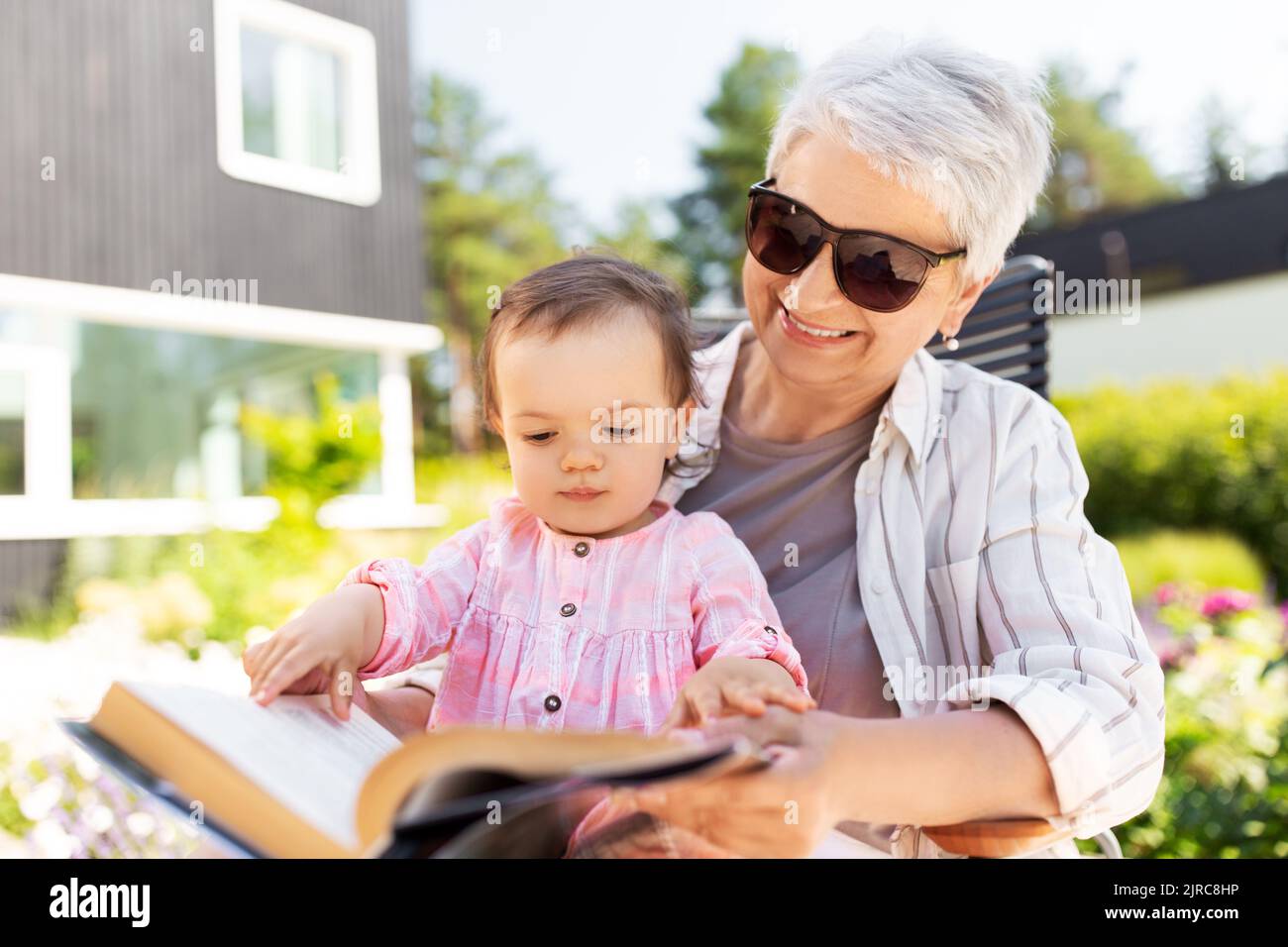 grandmother and baby granddaughter reading book Stock Photo - Alamy