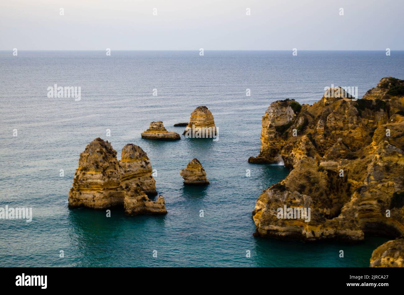 The brown and yellow rocky cliffs in the sea on a summer day Stock ...