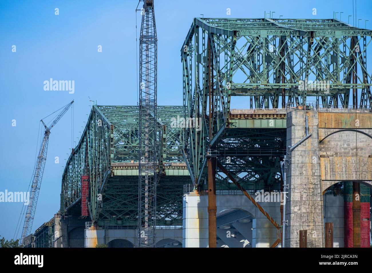 An old bridge is under demolition next to a new cable-stayed bridge ...